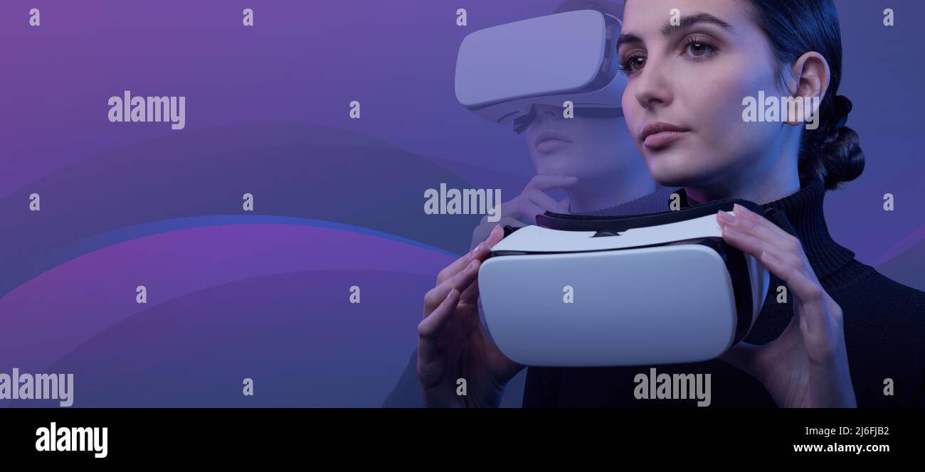 Young woman holding a VR headset and accessing virtual reality ...