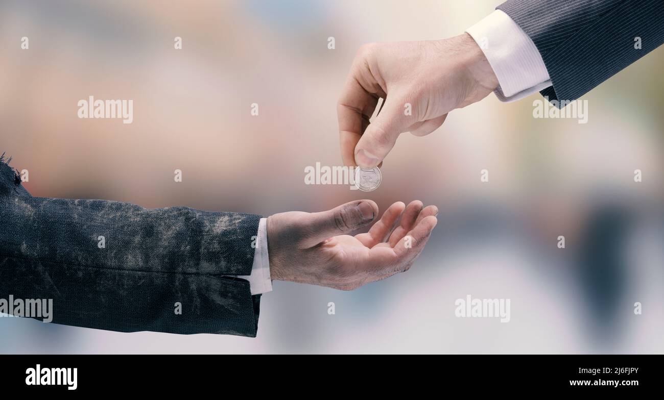 Business man with poor man giving money hi-res stock photography and ...