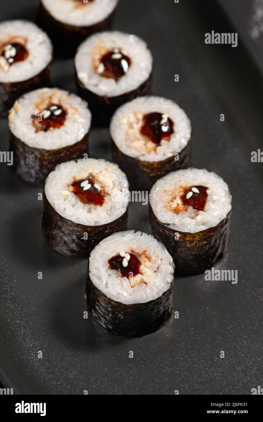 Simple maki with shrimp on a plate on black stone background. Flat lay ...
