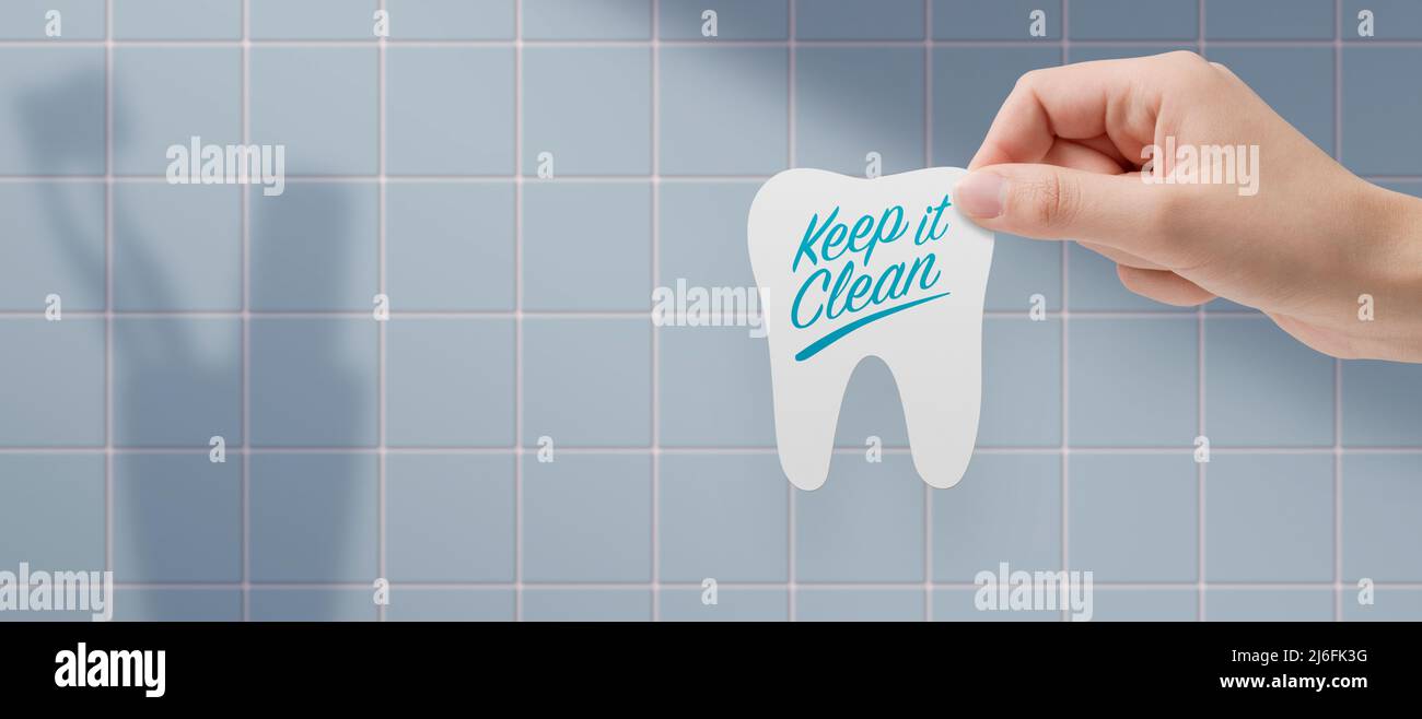 Woman holding a tooth shaped dental hygiene sticker Stock Photo - Alamy