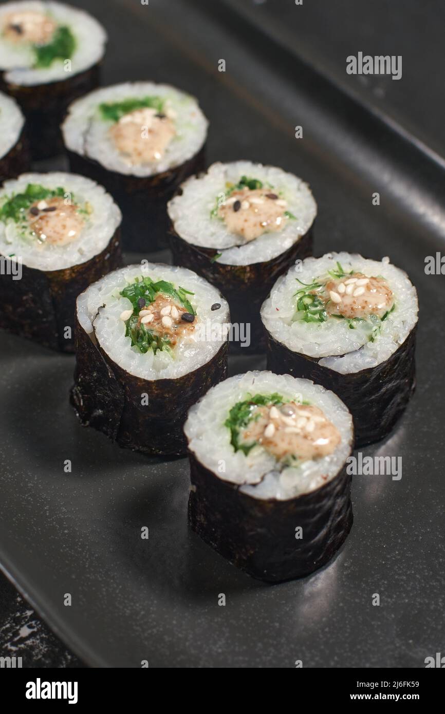Simple maki with shrimp on a plate on black stone background. Flat lay ...