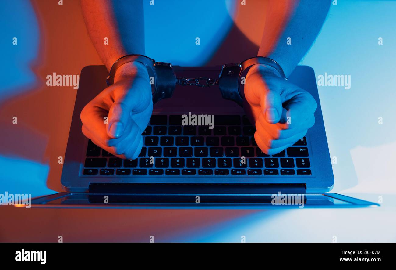 Man in handcuffs at the computer. Cyber crime concept Stock Photo - Alamy