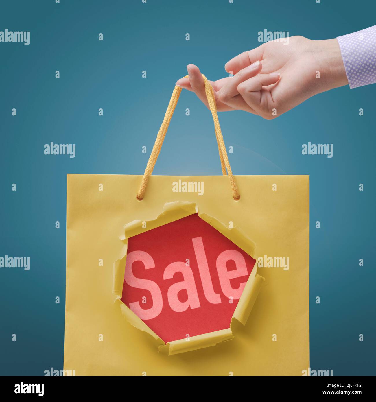Customer holding a shopping bag with a torn hole and sale text ...