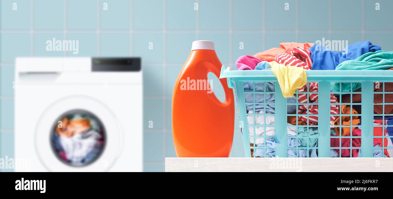 Full washing machine and laundry detergents, household chores concept ...