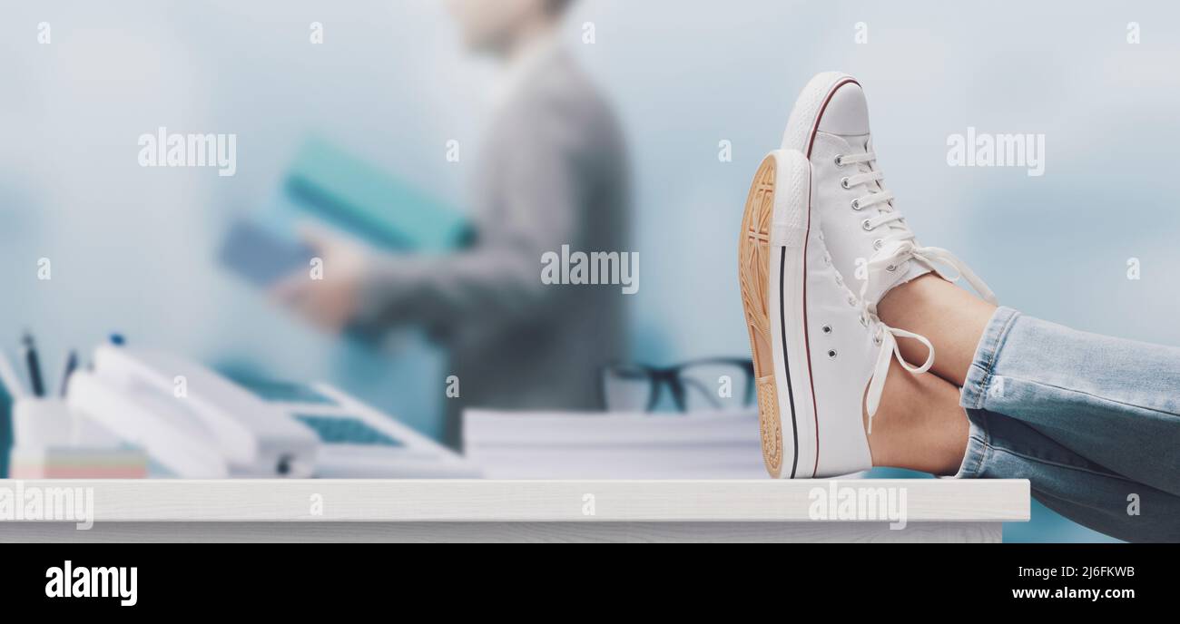 Woman taking a break from her work, she is relaxing with feet up on the ...