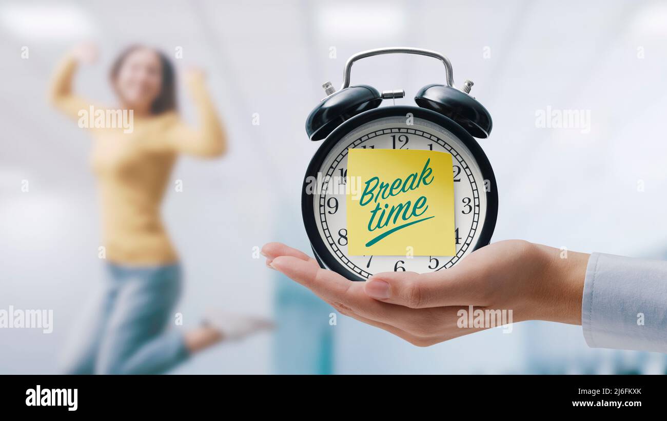 Hand showing a vintage clock with sticky note and happy woman jumping ...