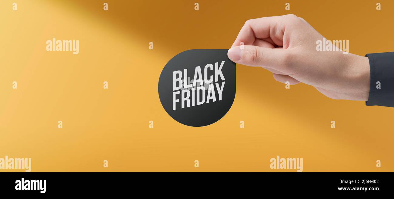 Hand holding a Black Friday promotional label, sales and offers concept ...