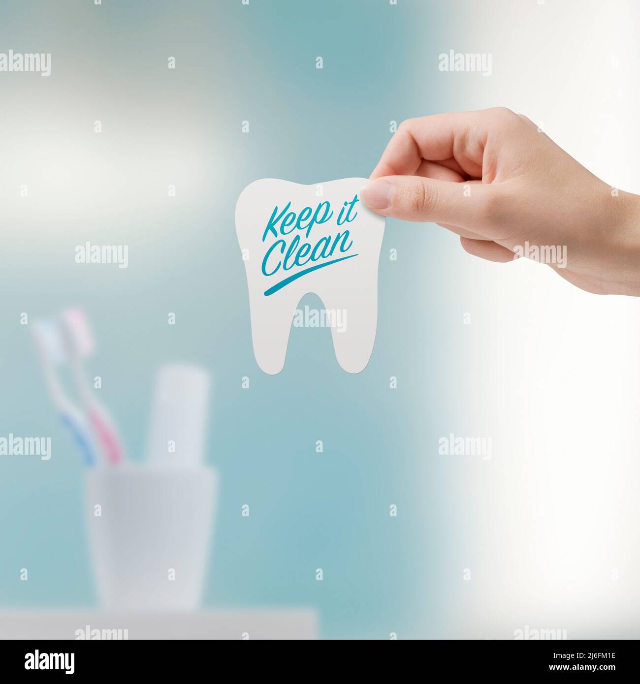 Woman holding a tooth shaped dental hygiene sticker Stock Photo - Alamy