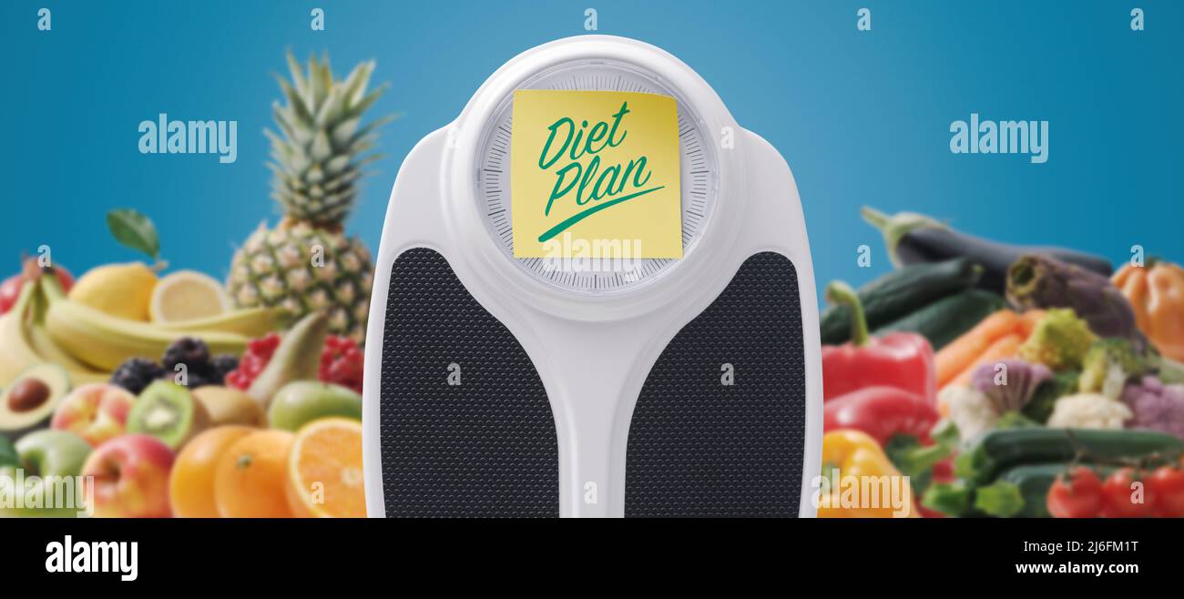 Weight scale with diet plan reminder, lots of healthy vegetables and ...