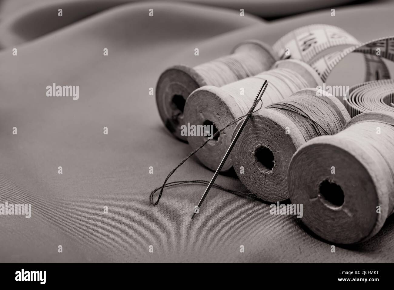 Vintage retro spool of thread on a black and white fabric background ...