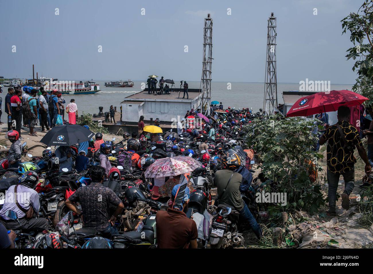 People wait in a queue to board a ferry travelling to their native ...