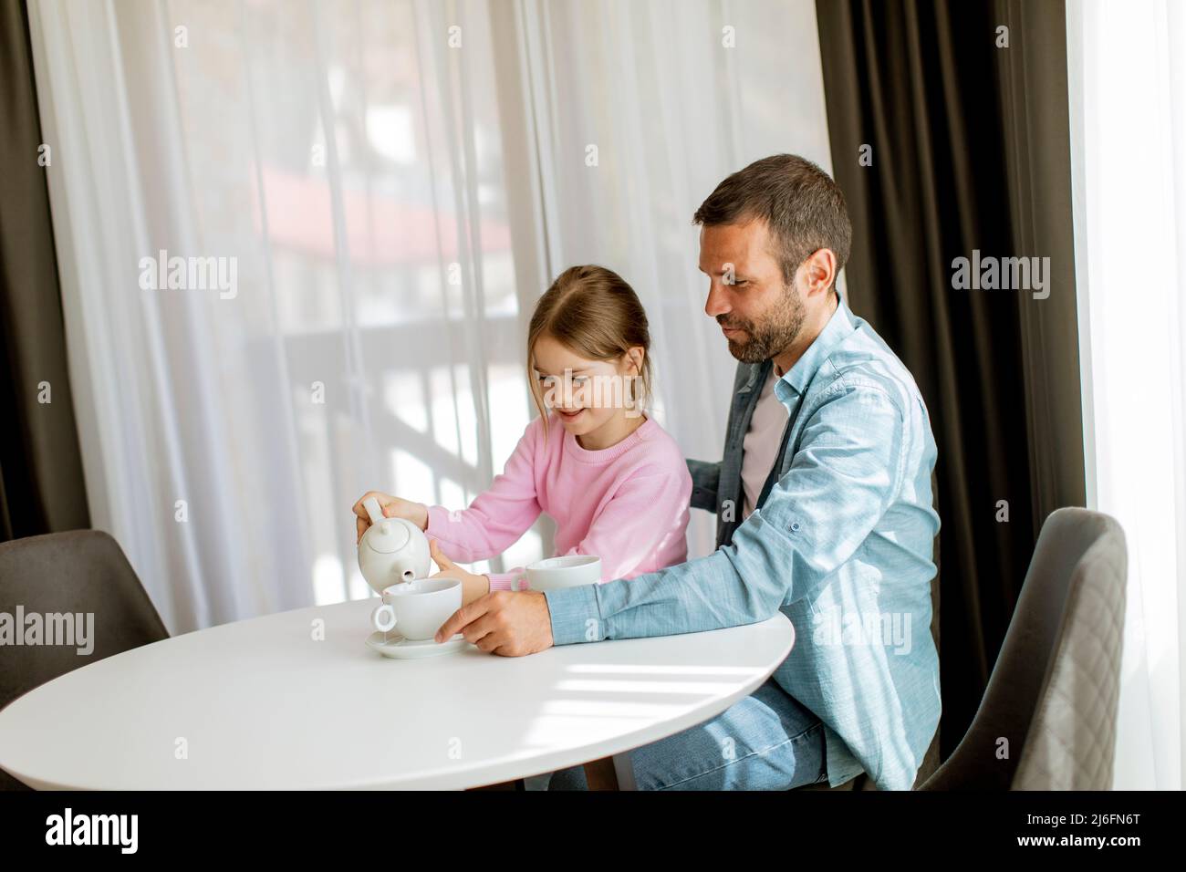 Father and daughter drinking tea together at the living room Stock ...