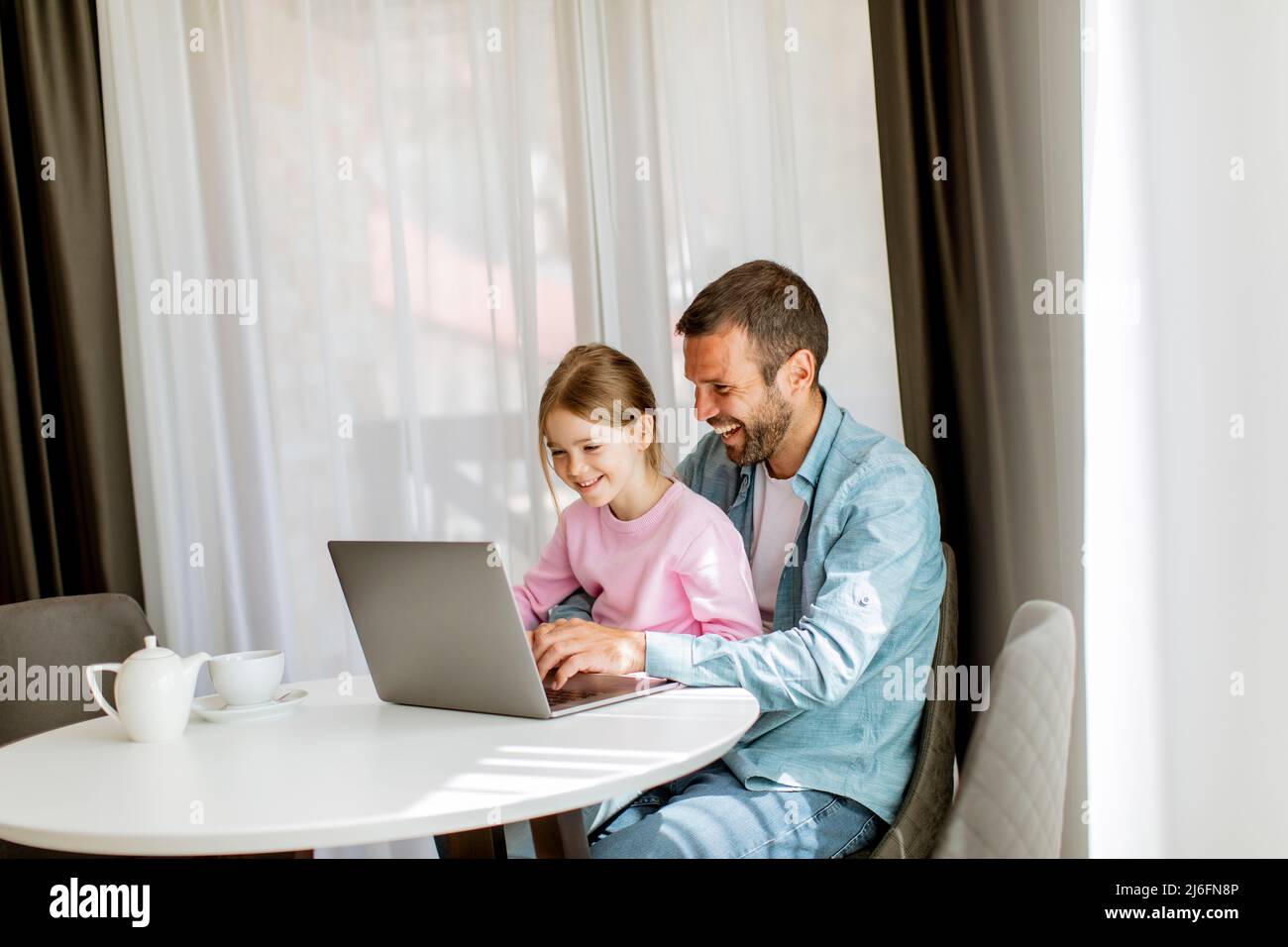 Father and daughter using laptop computer together in the room Stock ...