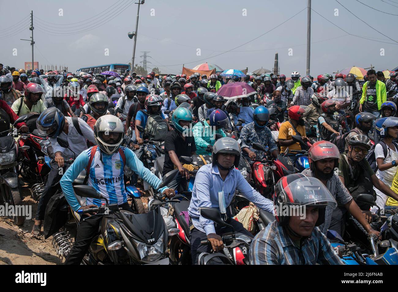 People wait in a queue to board a ferry travelling to their native places ahead of the Eid al ...