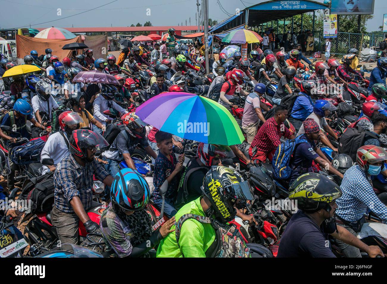 People wait in a queue to board a ferry travelling to their native ...
