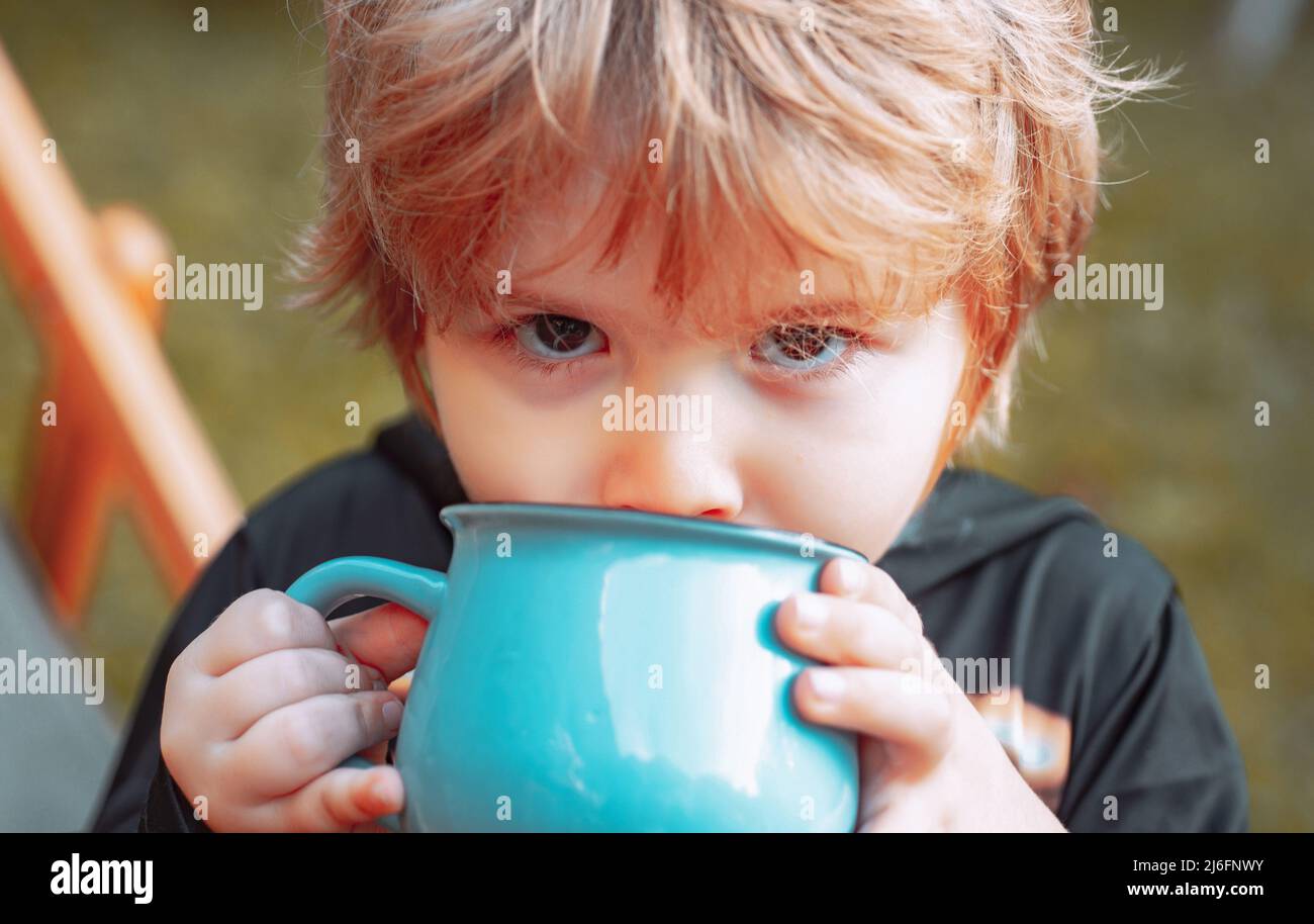Boy drinking something. Little child have fun on fresh air. Portrait of ...