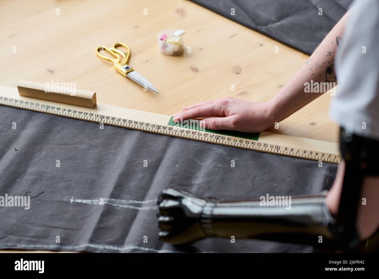 Arm prosthesis of young female tailor or fashion designer working with ...