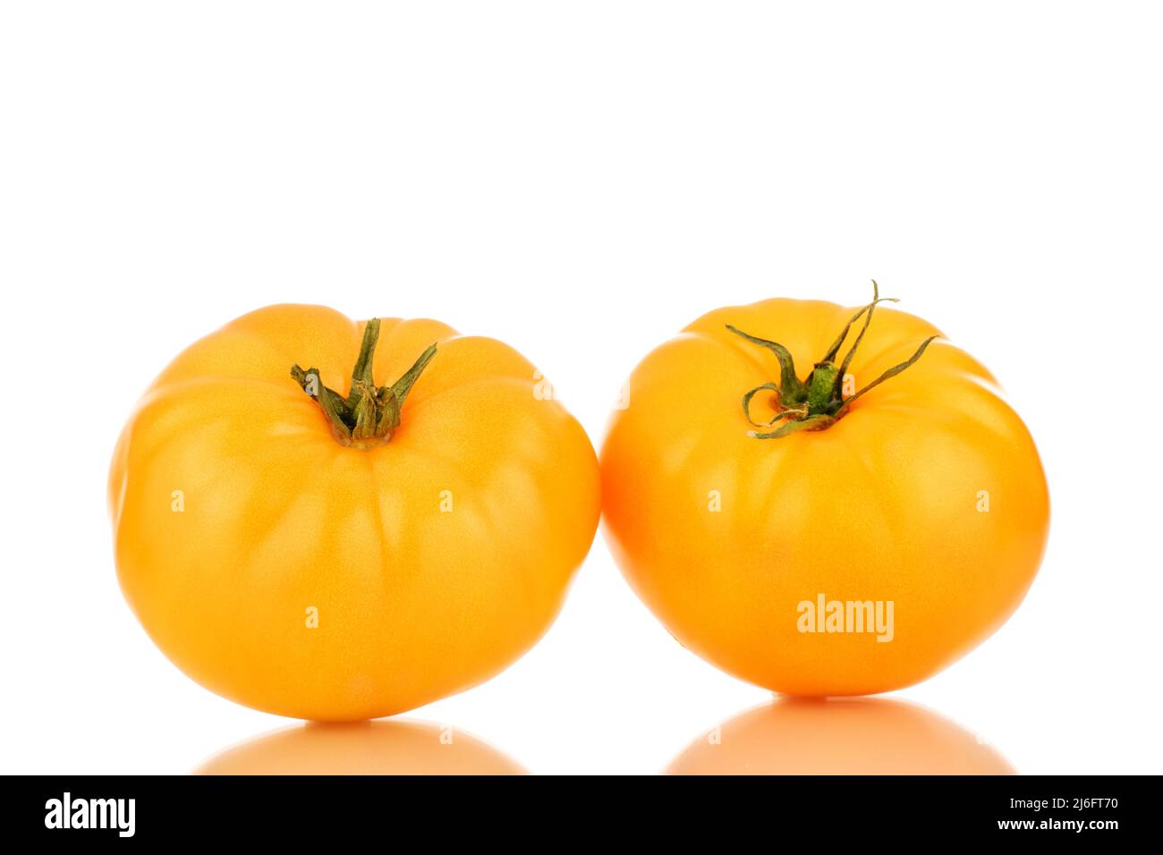 Two juicy organic, yellow tomatoes, close-up, isolated on a white ...