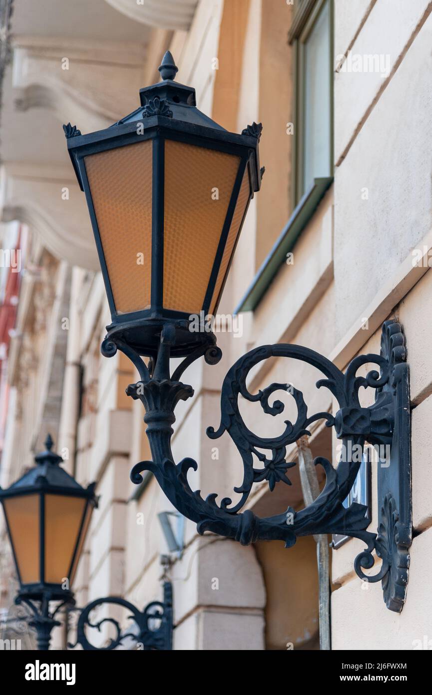 Old street lantern lighting on facade of building. Twilight on city ...
