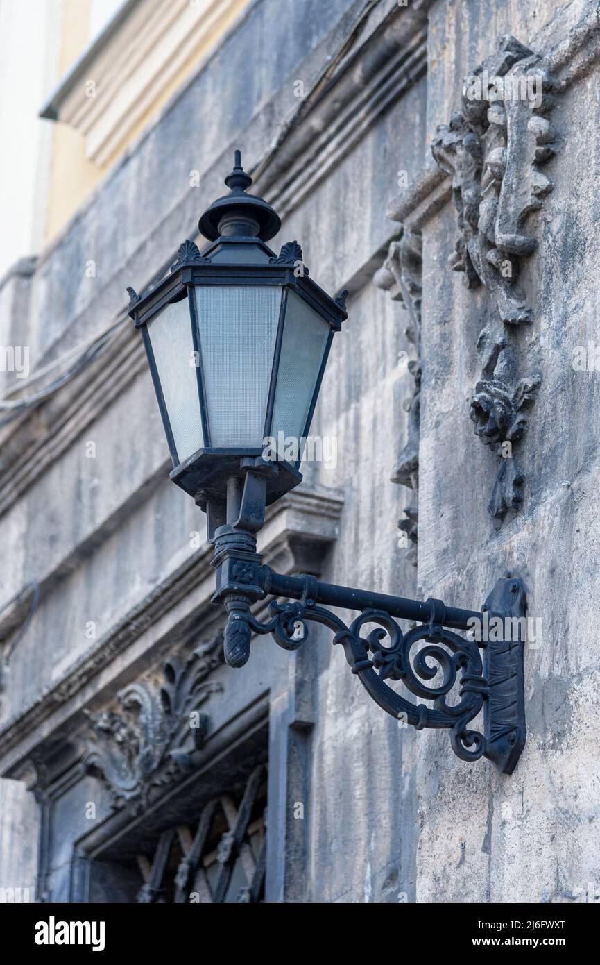 Old street lantern lighting on facade of building. Twilight on city ...