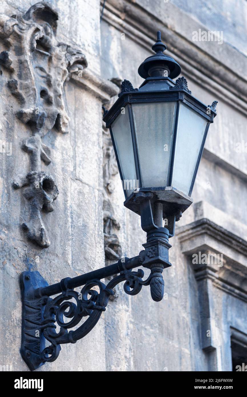Old street lantern lighting on facade of building. Twilight on city ...