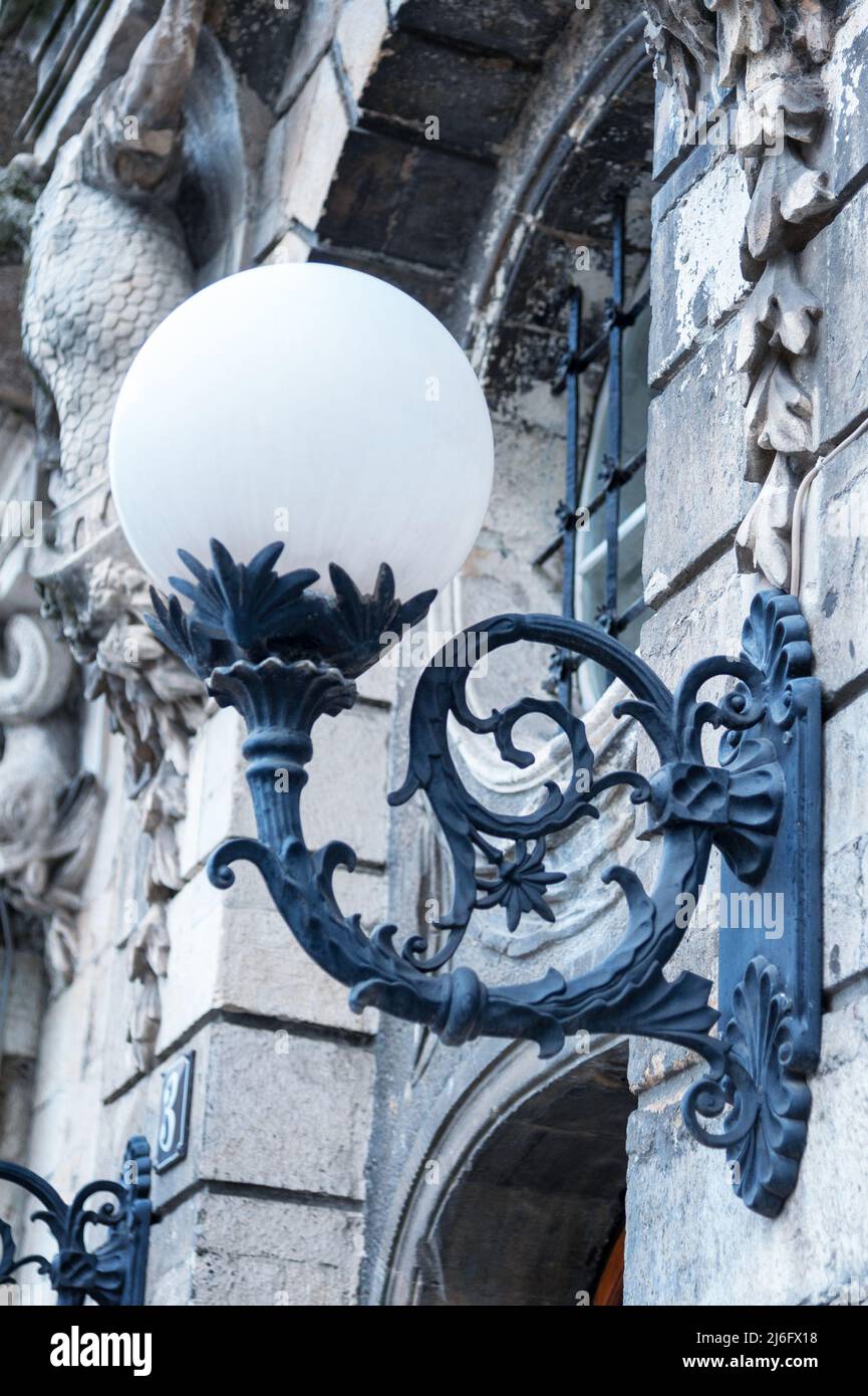 Old street lantern lighting on facade of building. Twilight on city ...