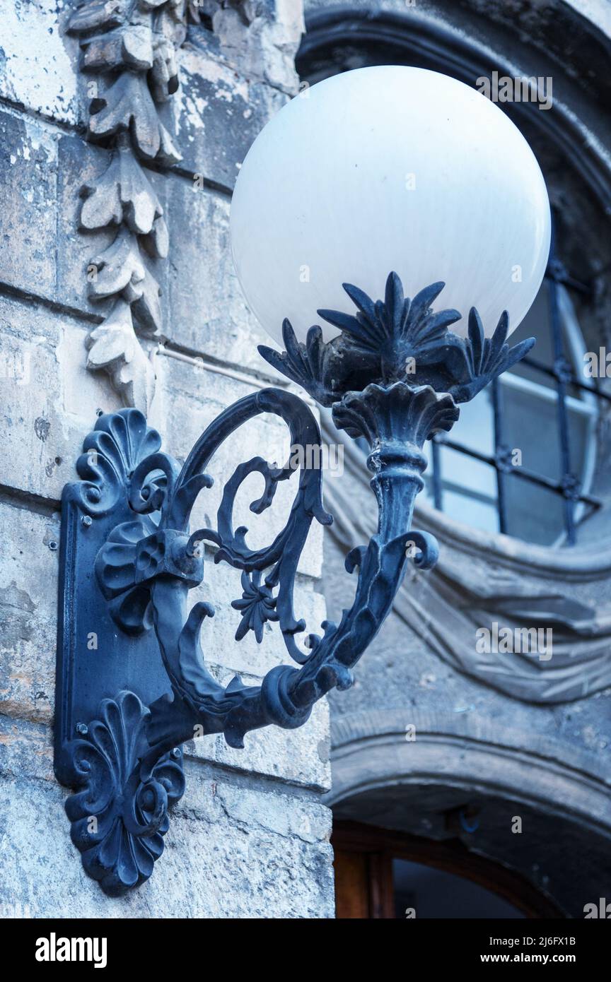 Old street lantern lighting on facade of building. Twilight on city ...