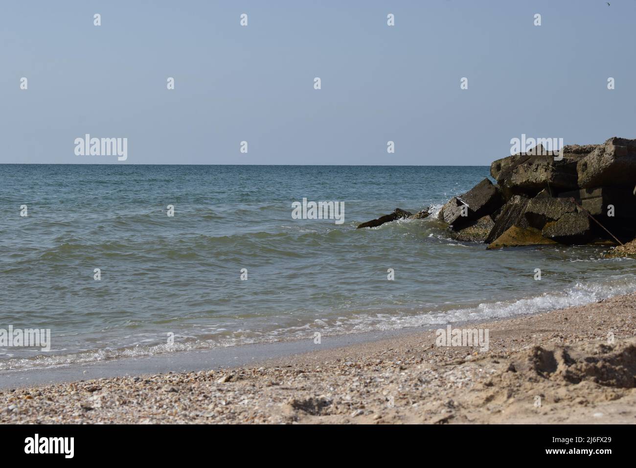Rock fragments on a wild beach. The sky was clear and the waters of the ...