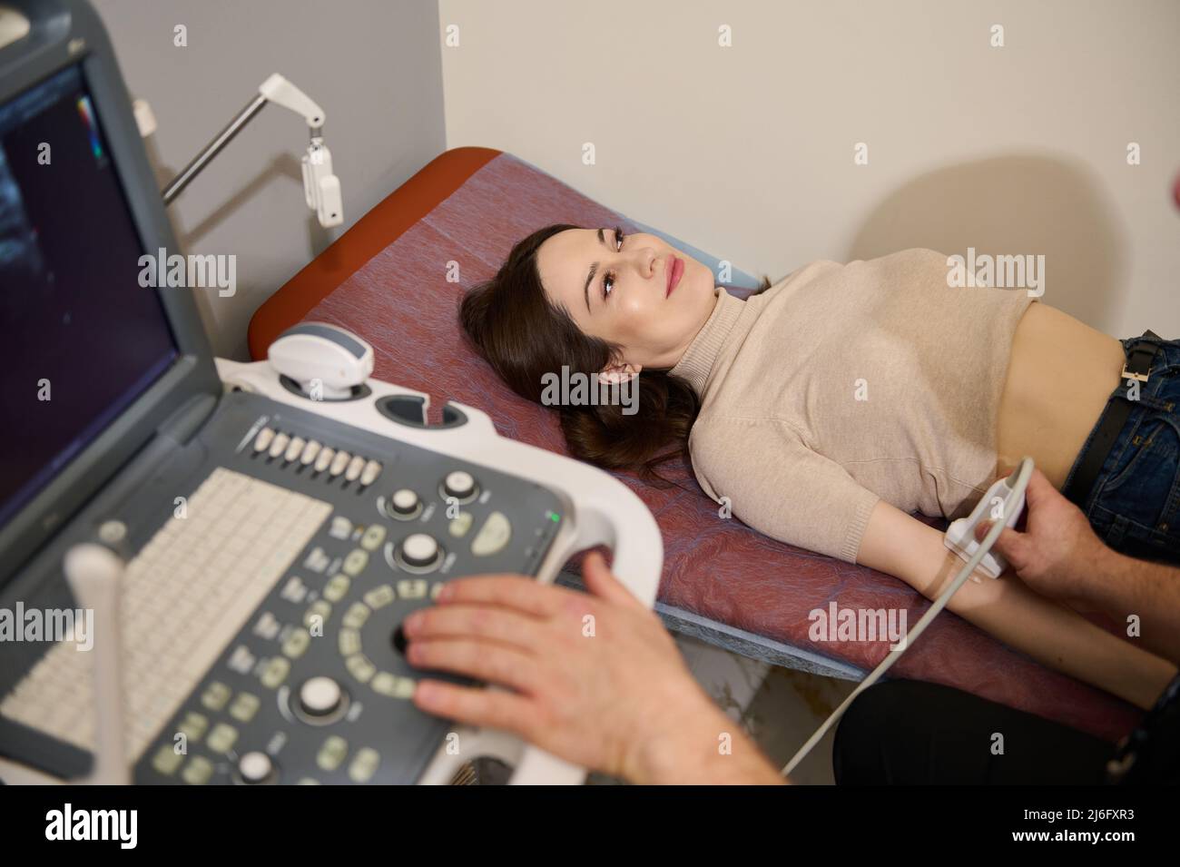 Beautiful female patient lies on a medical couch during an examination ...