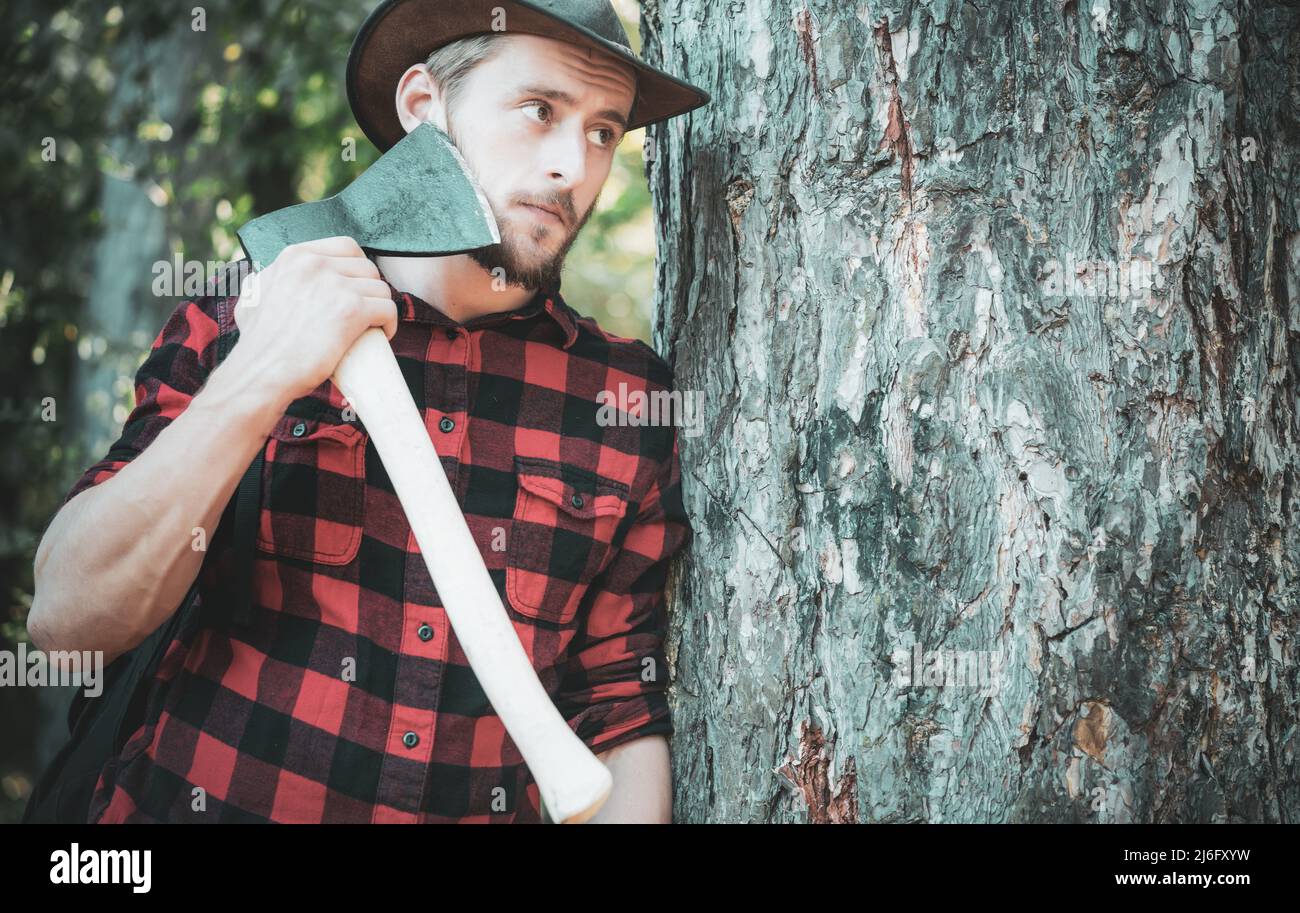 Woodcutter with axe in the summer forest. Lumberjack standing with axe ...
