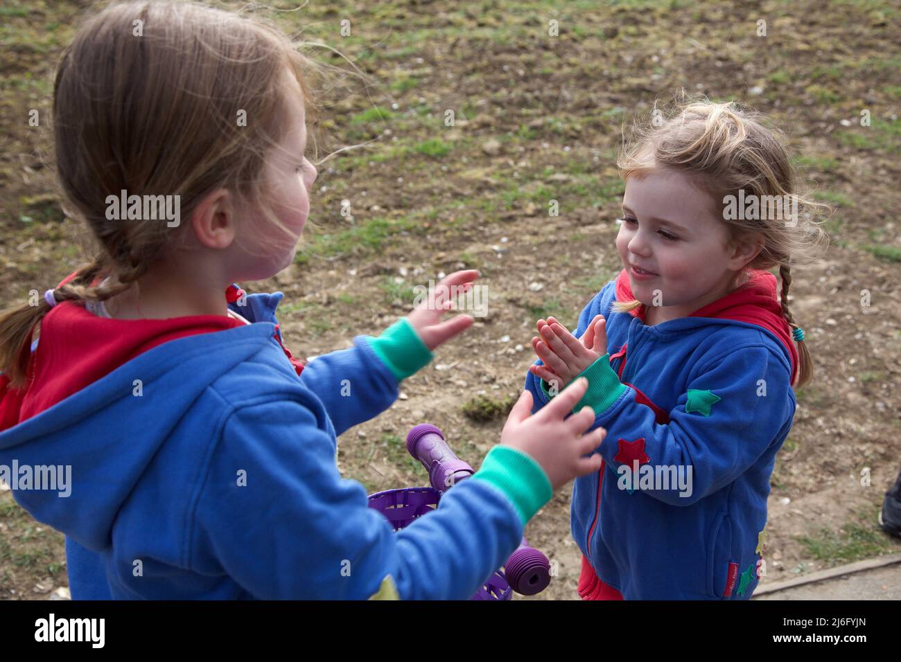 Kids playing Pat a Cake game, UK Stock Photo - Alamy