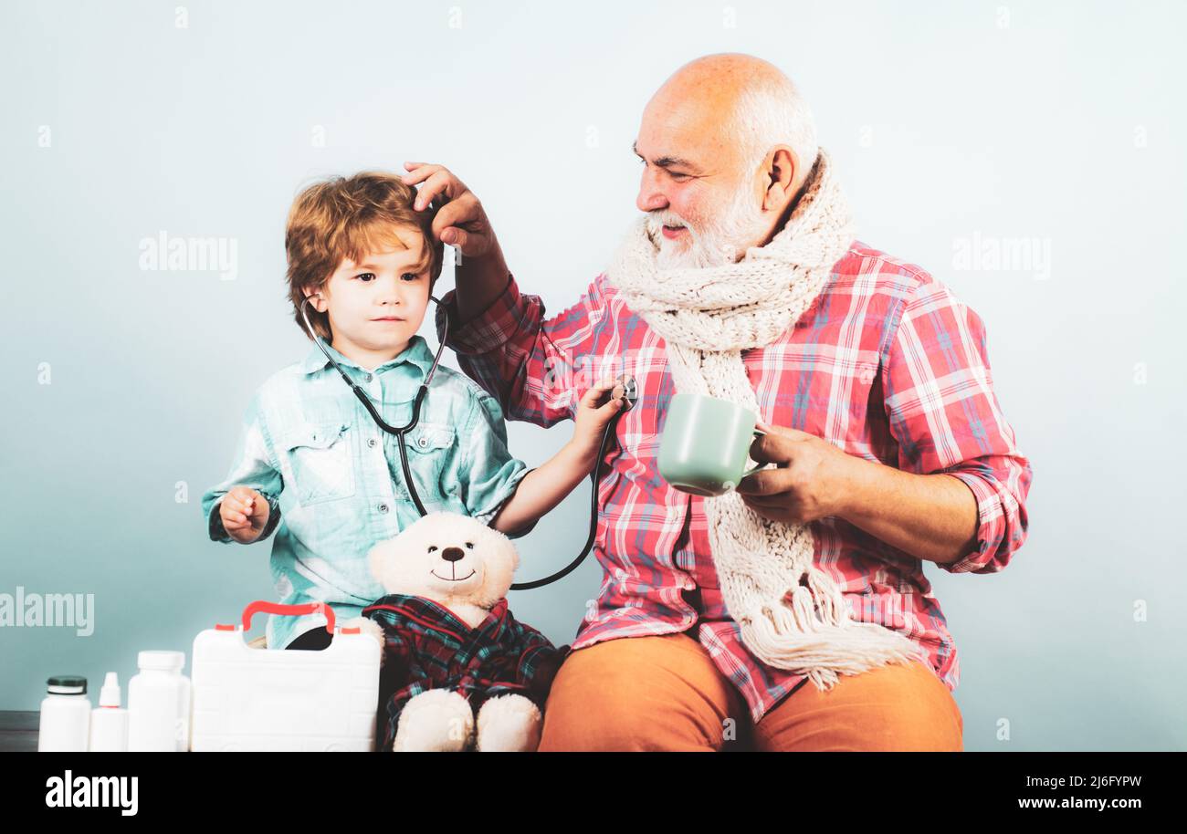 Little doctor giving grandfather medicament. Little doctor using a ...