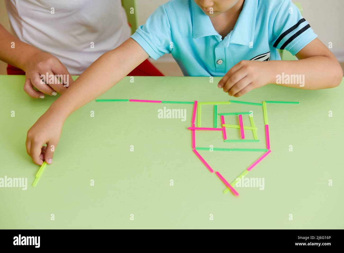 Teacher and preschool child building house on a table Stock Photo - Alamy