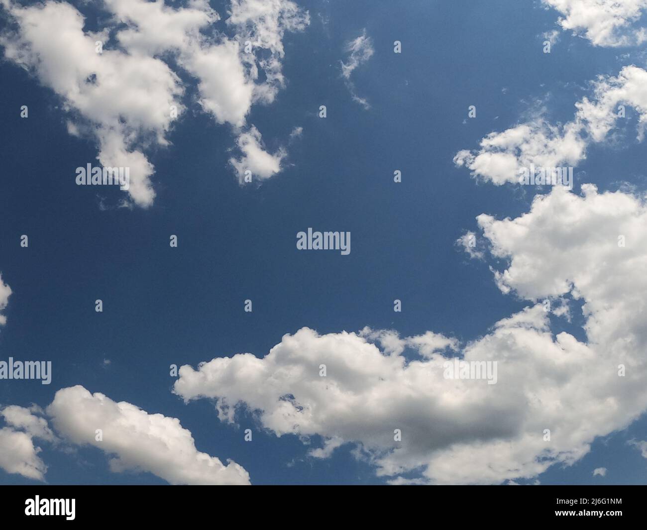 Perfect blue sky with fluffy white clouds in diagonally formation. The ...