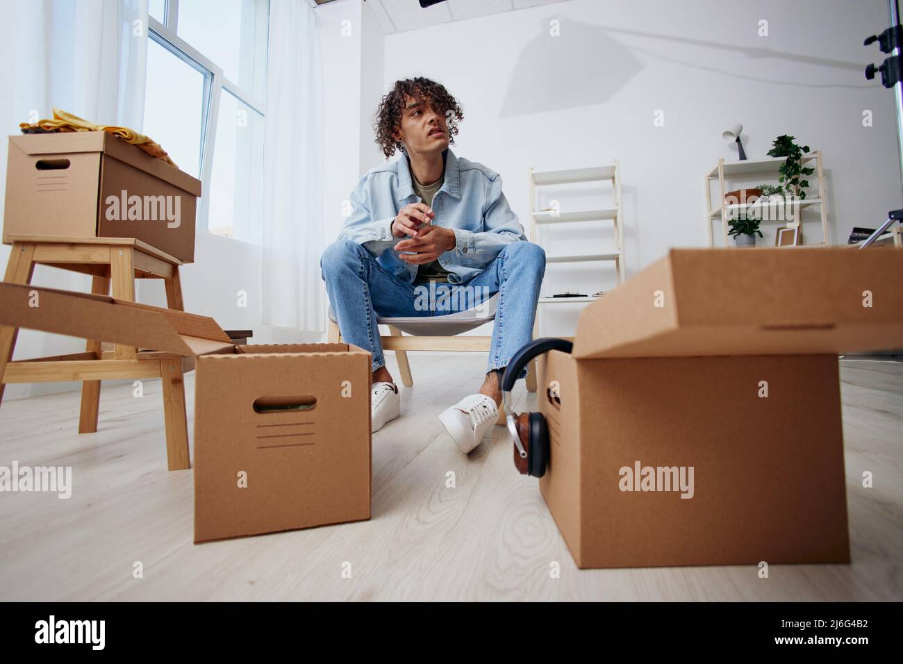 A young man unpacking things from boxes in the room Lifestyle Stock ...