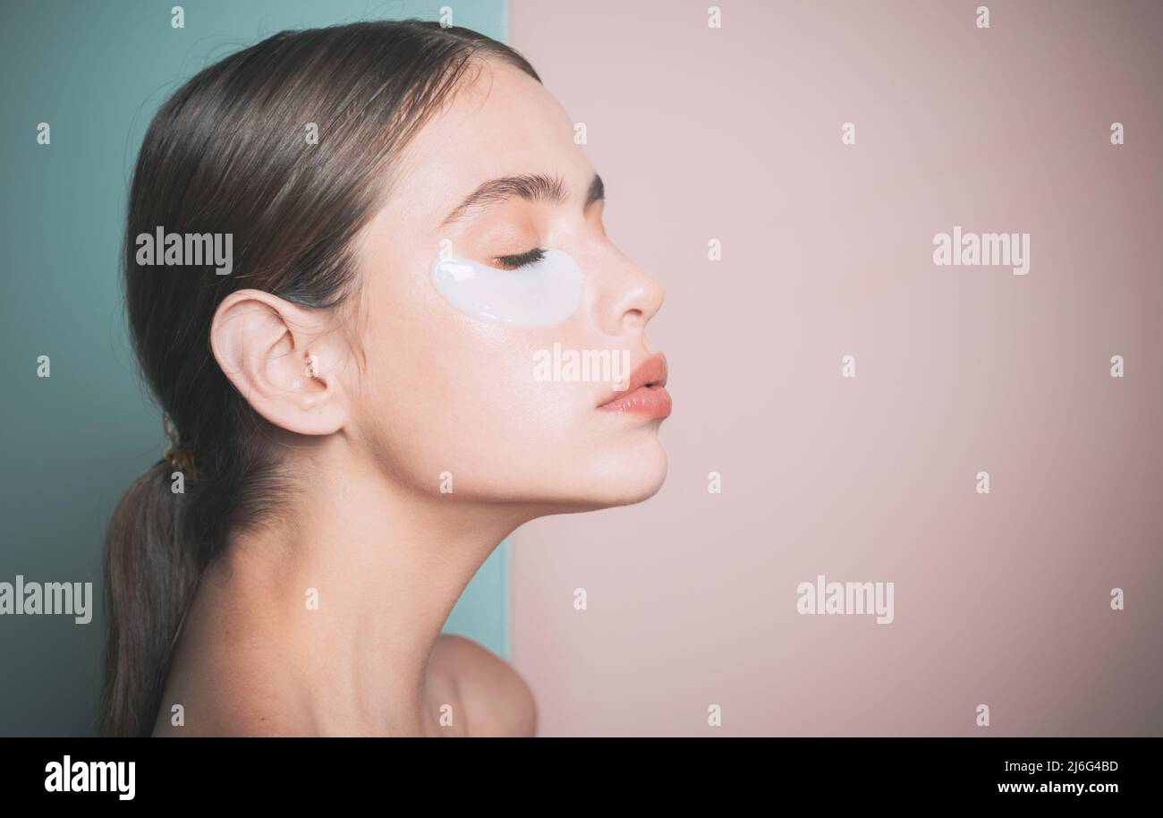 Taking care of her skin. Woman using eye patches spending time at home ...