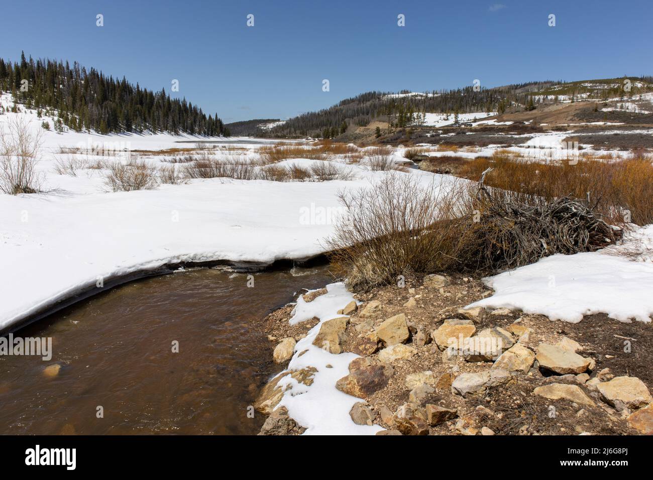 A river flows through a snowy bank at State Forest State Park in the ...