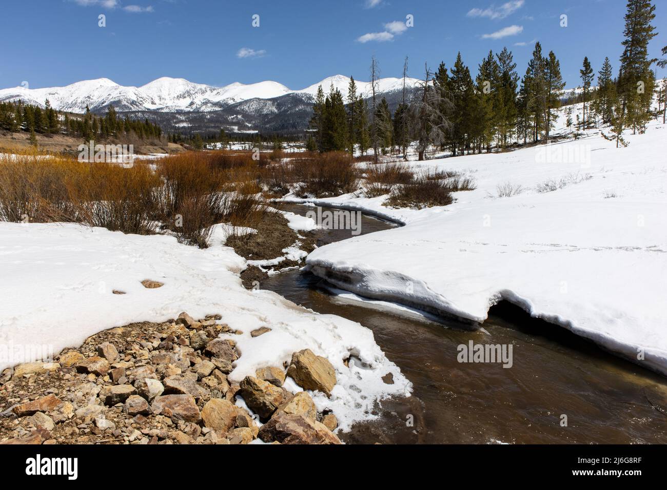 A river flows through a snowy bank at State Forest State Park in the ...