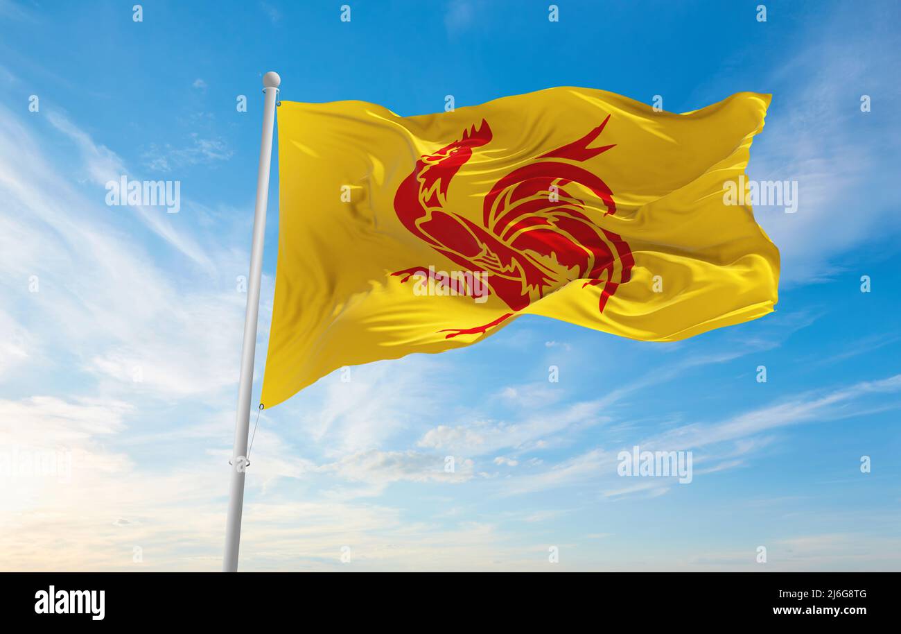official flag of Wallonia, Belgium at cloudy sky background on sunset ...