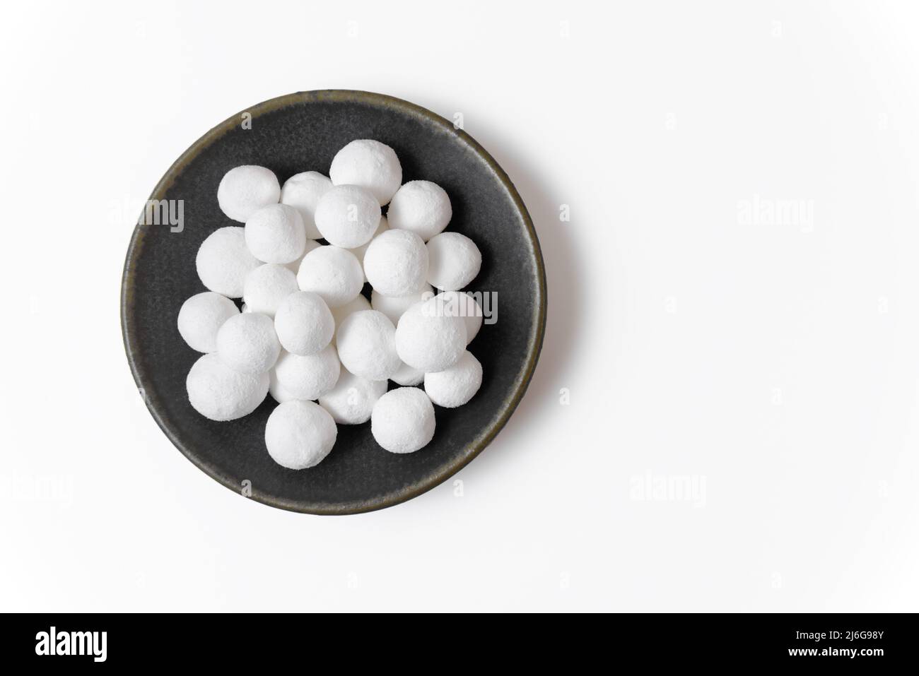 White delicious sugar balls in a gray plate isolated on a white ...