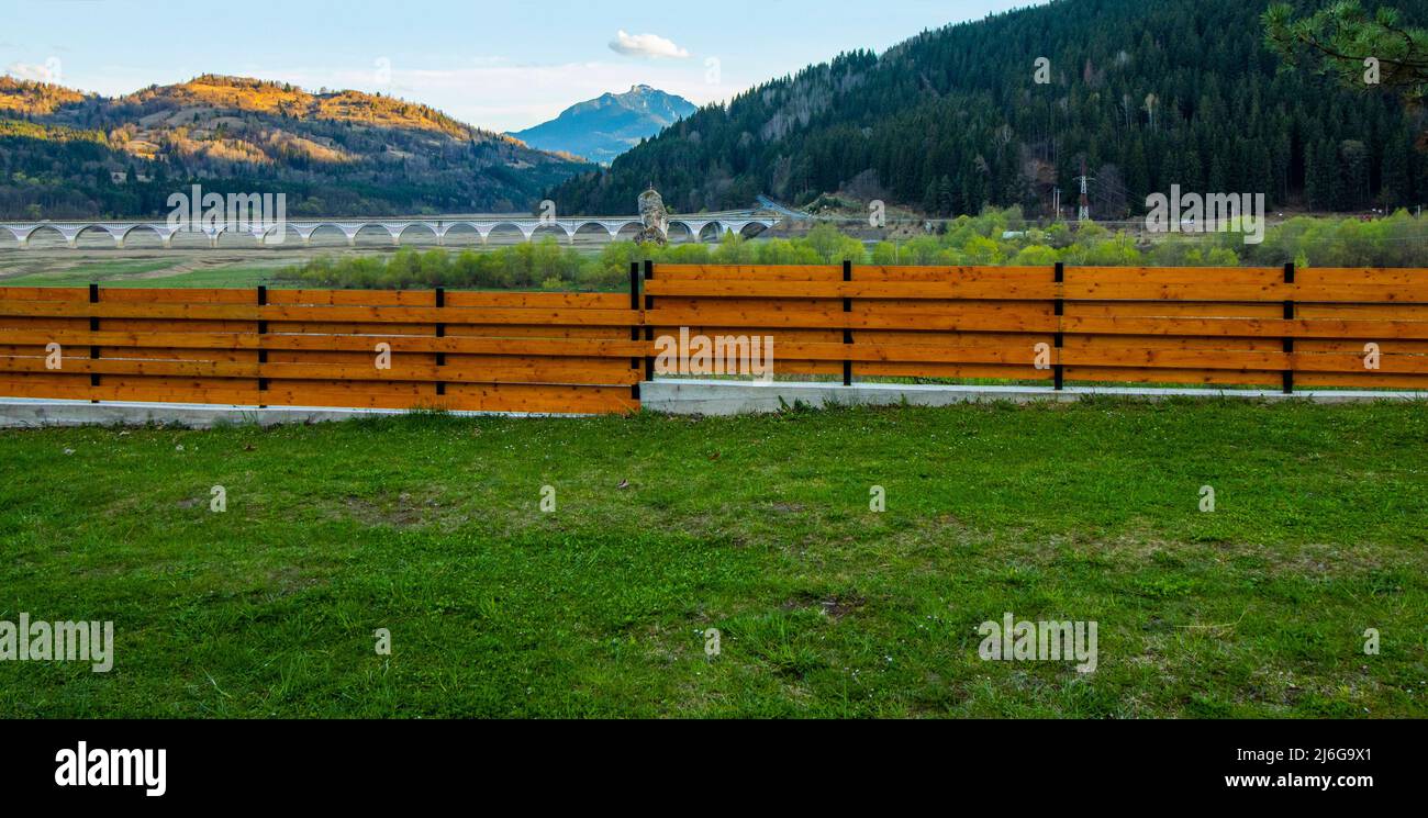fence and green grass in nature. Poiana Teiului viaduct in background ...