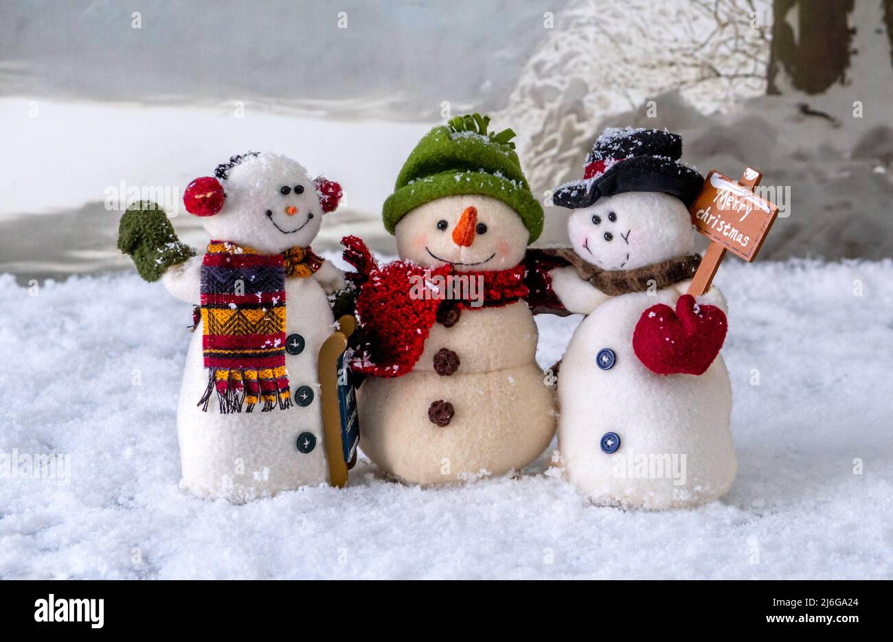Trio of happy snowmen friends hug as they stand in the middle of a ...