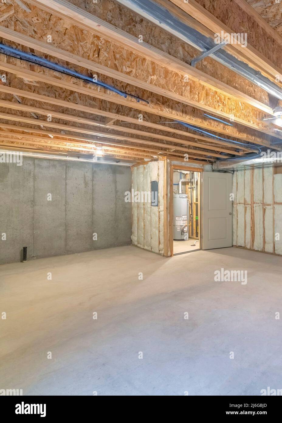 Vertical Empty unfinished large basement with concrete flooring and ...