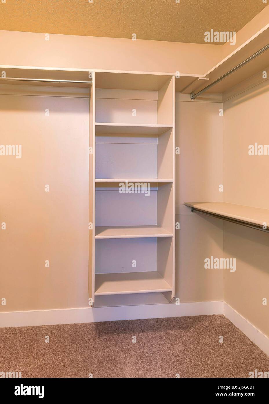 Vertical Empty walk-in closet with warm color lighting and shelving ...