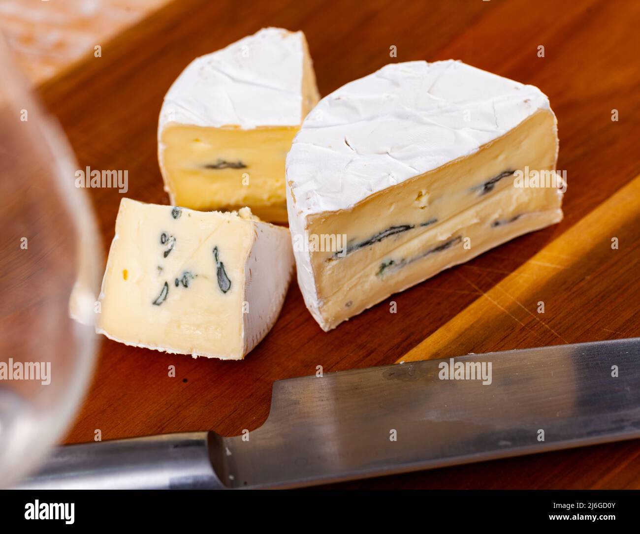 Whole wheel of piquant creamy blue cheese on cutting board Stock Photo ...