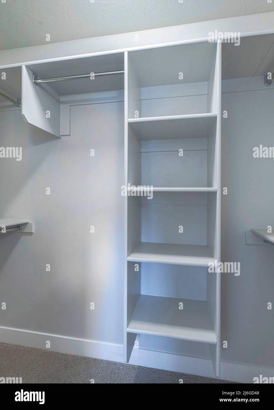 Vertical Empty small windowless walk in closet with open wardrobe Stock ...