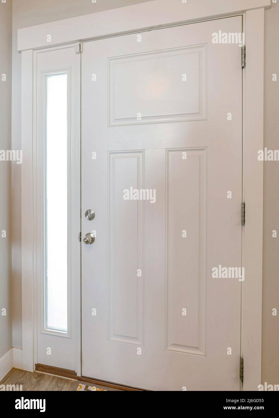 Vertical Interior of a white front door of a house with side glass ...