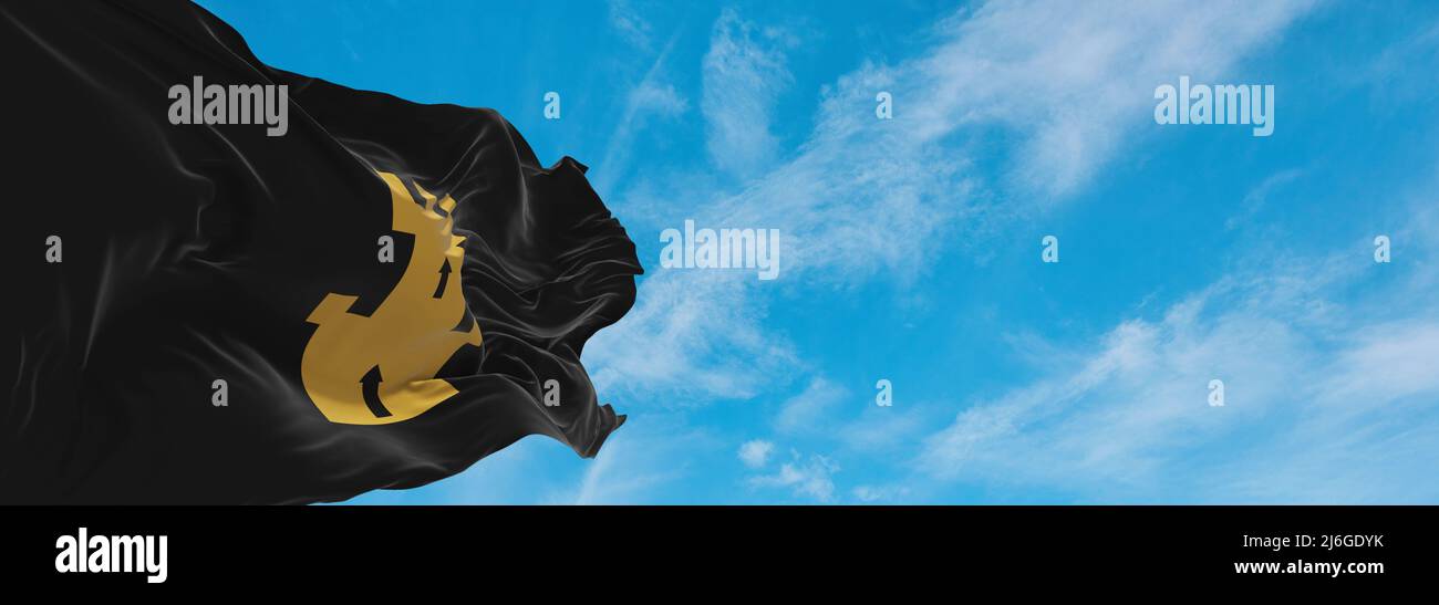 official flag of Finnmark , Norway at cloudy sky background on sunset ...