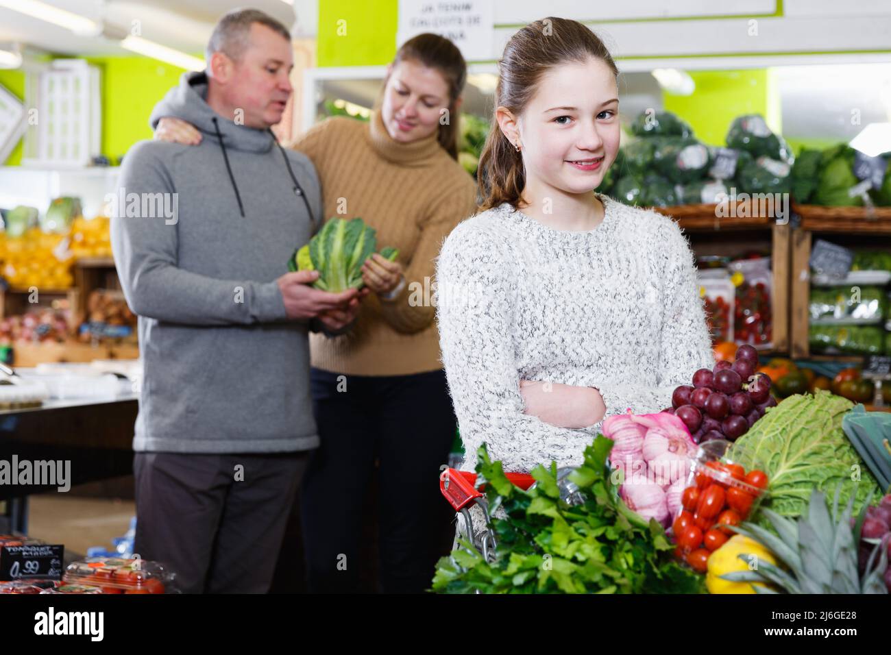 Happy girl with parents in fruits market Stock Photo - Alamy