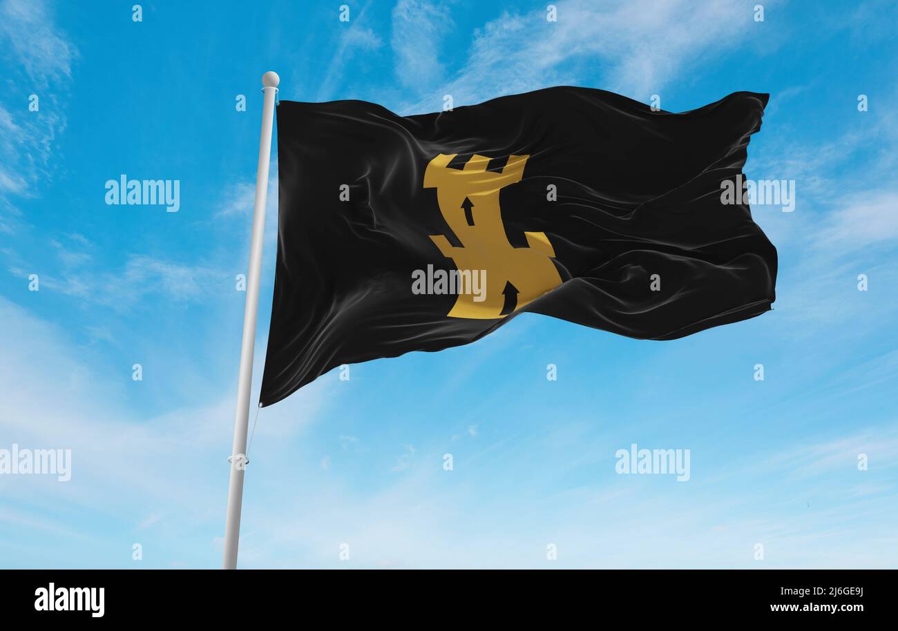 official flag of Finnmark , Norway at cloudy sky background on sunset ...